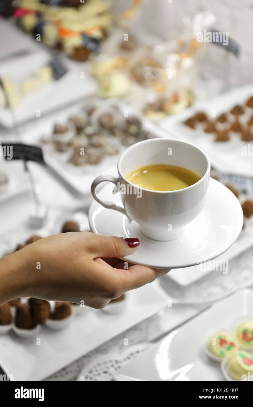 Female hand holding cup of coffee on table background Stock Photo - Alamy