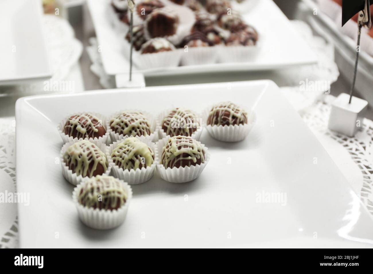 Delicious chocolate candies on plate close up Stock Photo - Alamy