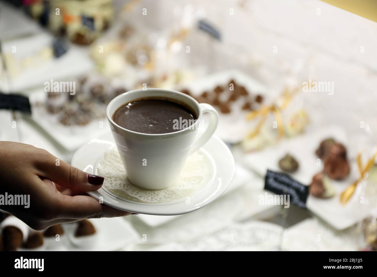 Female hand holding cup of coffee on table background Stock Photo - Alamy