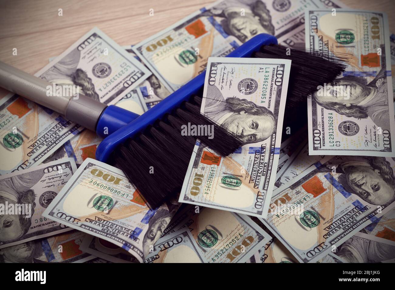 Dollars and broom on wooden floor, closeup Stock Photo - Alamy