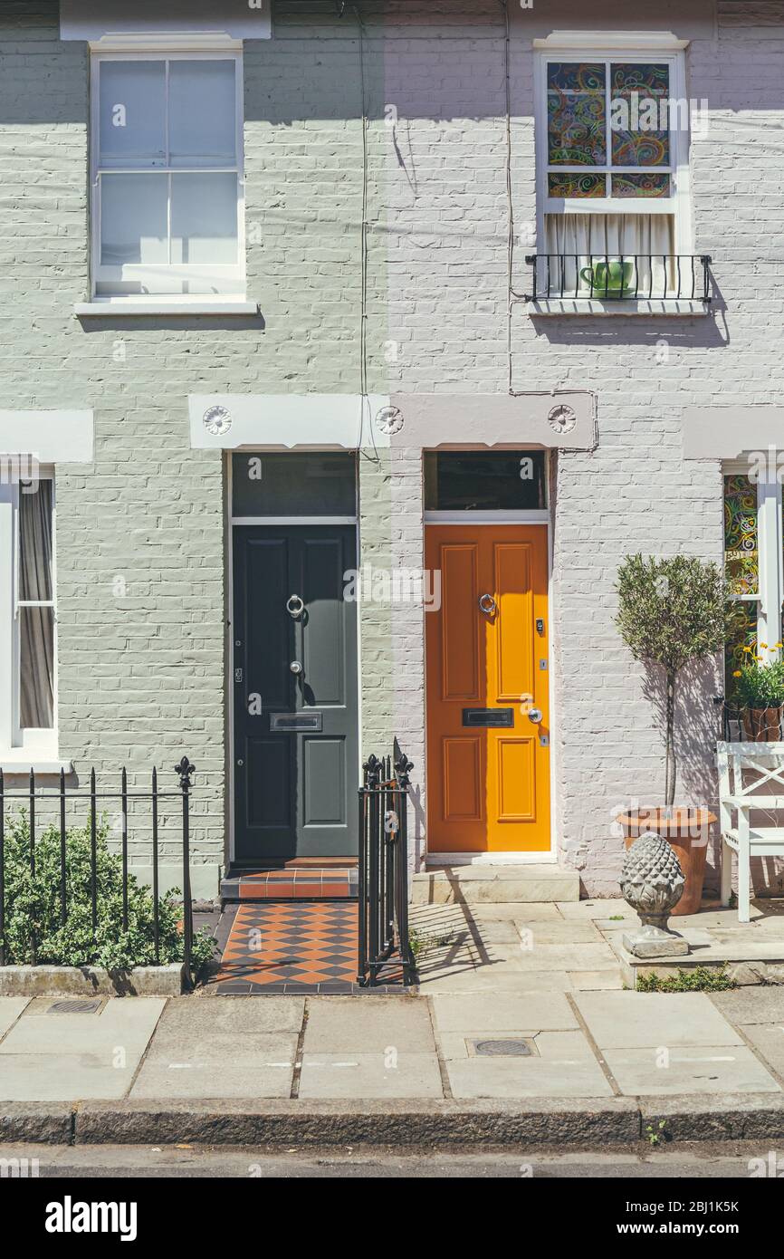 Colorful bright orange and grey doors on a facade of British terrace ...