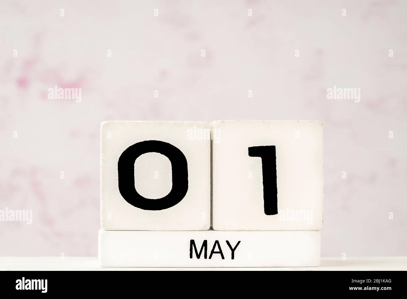 White cube calendar for May against soft pink background with copy ...