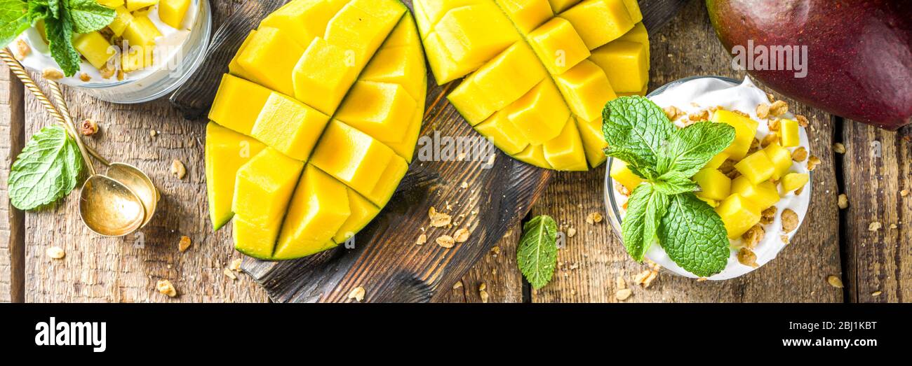 Summer breakfast layered dessert with mango and granola. Mango parfaits ...