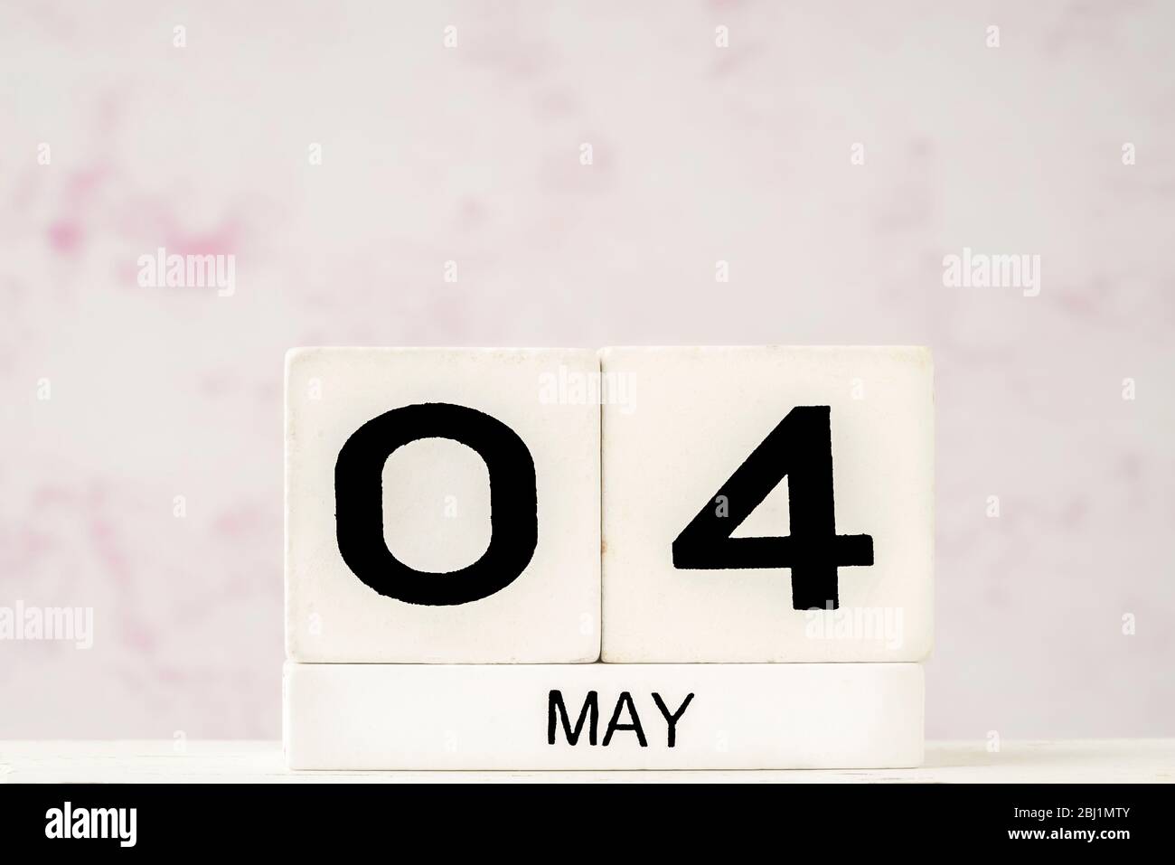 White cube calendar for May against soft pink background with copy ...