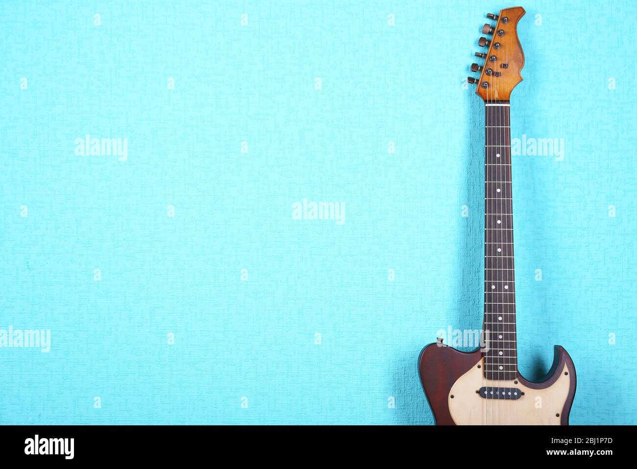 Electric guitar on blue wallpaper background Stock Photo - Alamy