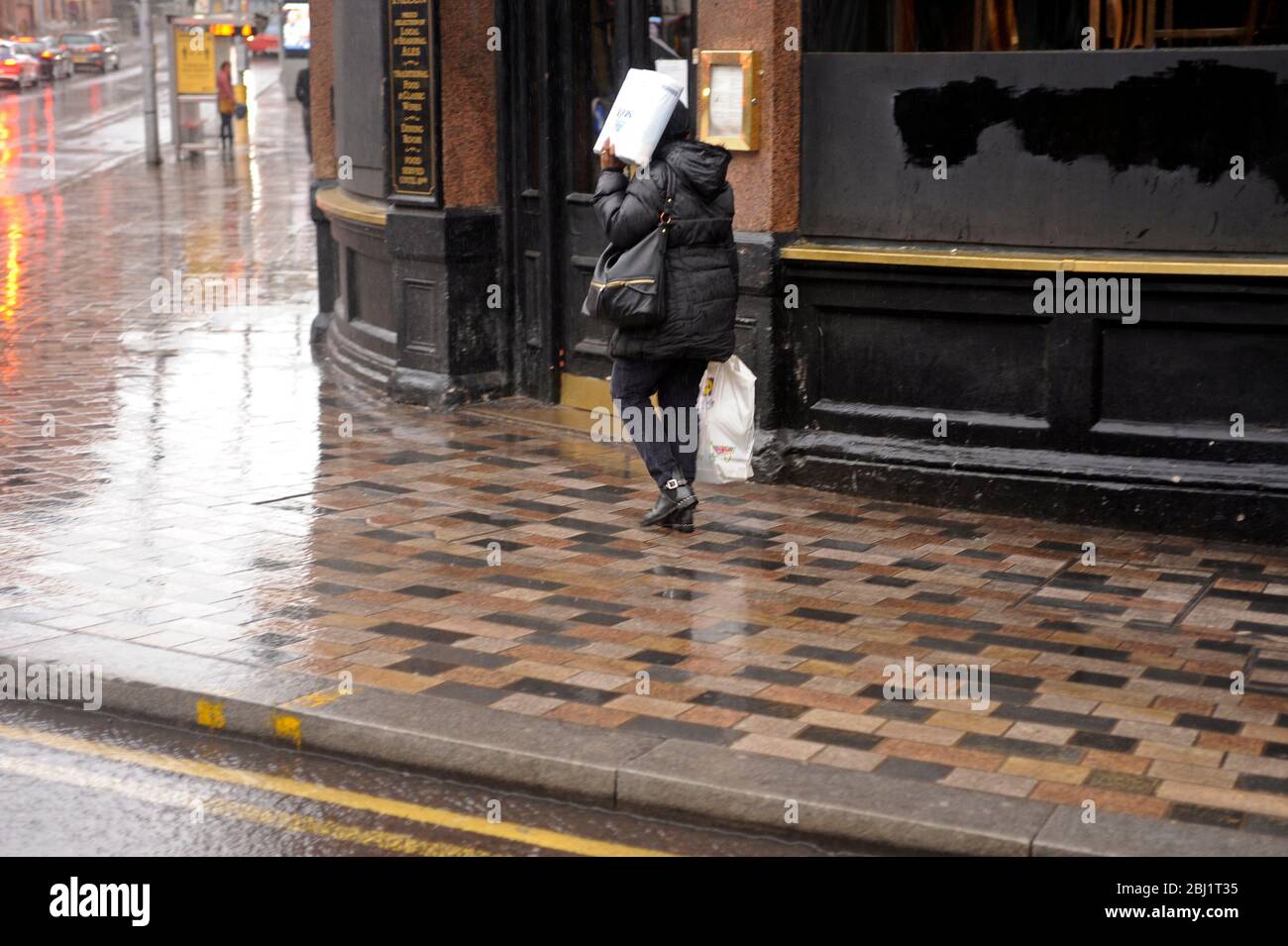 London, UK. 28th Apr, 2020. Woman uses pack of toilet rolls to shied ...