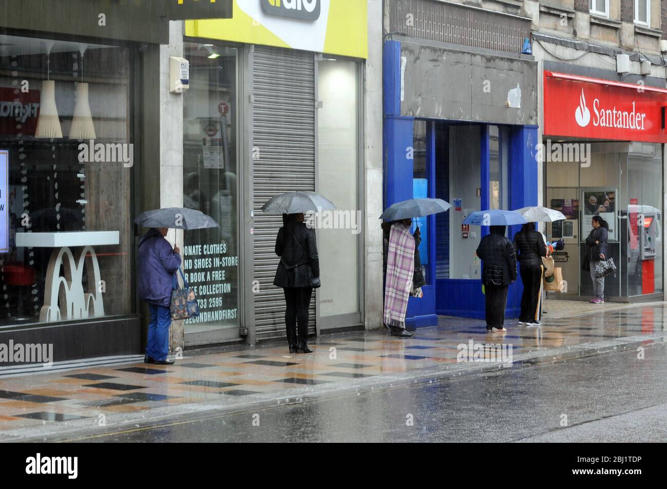 London, UK. 28th Apr, 2020. Sheltering from the rain at Clapham ...