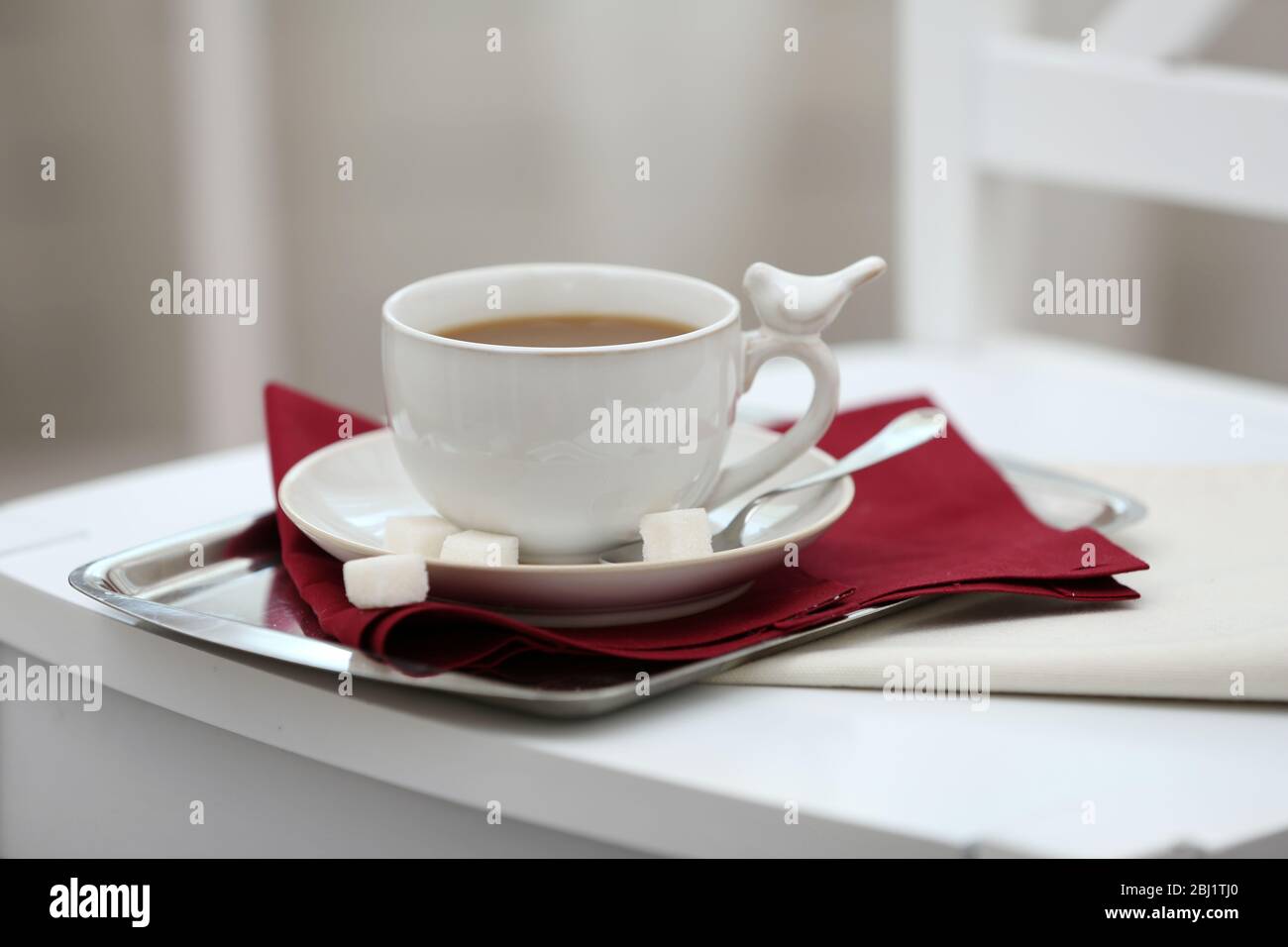 Cup of tea on chair in room Stock Photo - Alamy