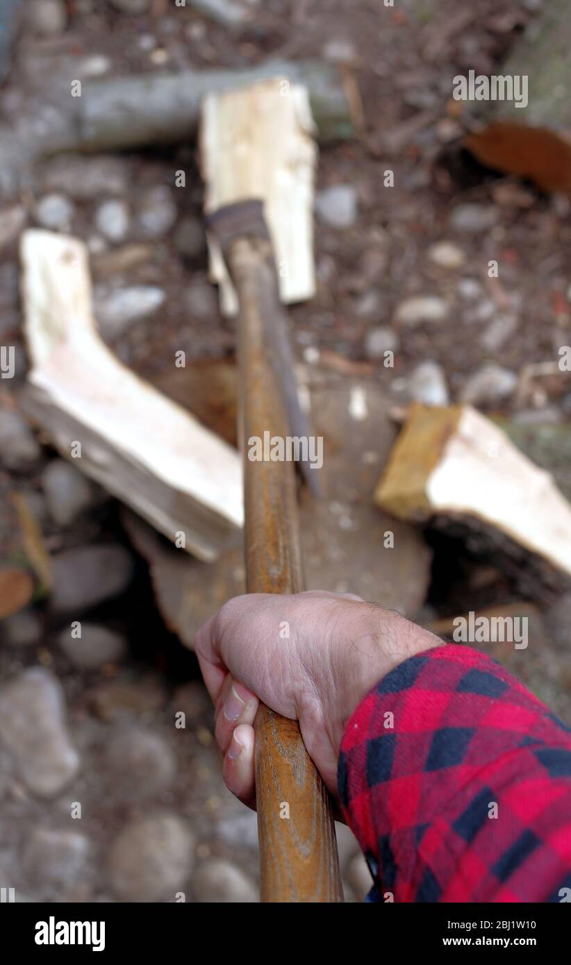 man with an old axe chops firewood log Stock Photo - Alamy