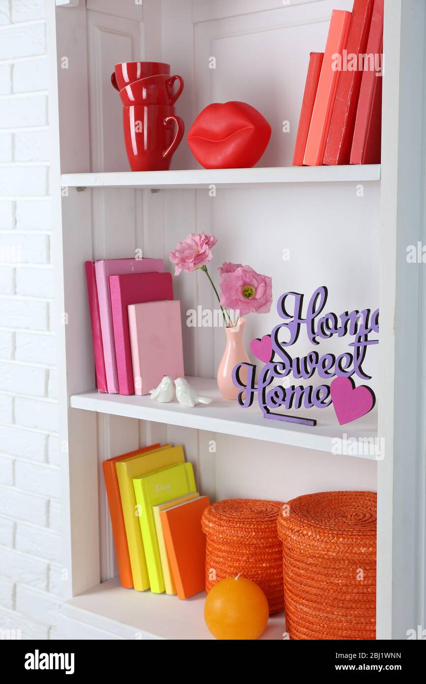Books and decor on shelves in cupboard Stock Photo - Alamy