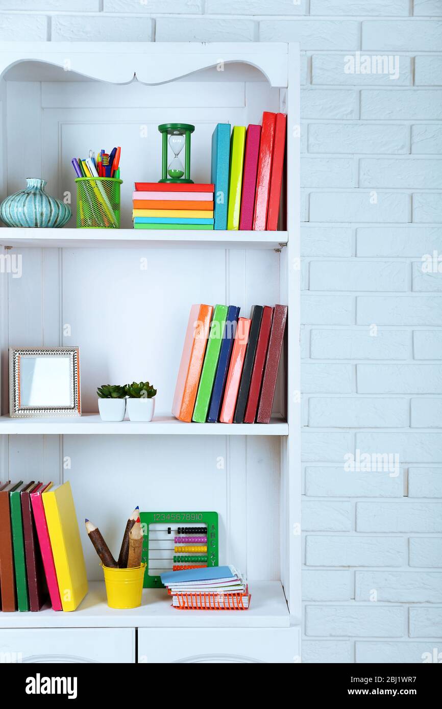 Books and decor on shelves in cupboard Stock Photo - Alamy
