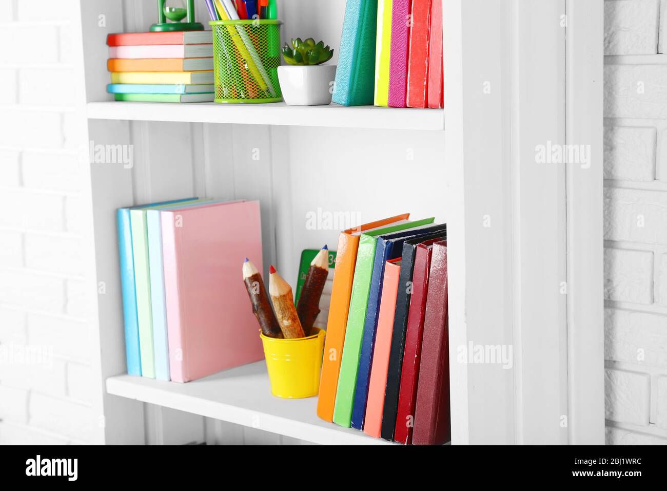 Books and decor on shelves in cupboard Stock Photo - Alamy