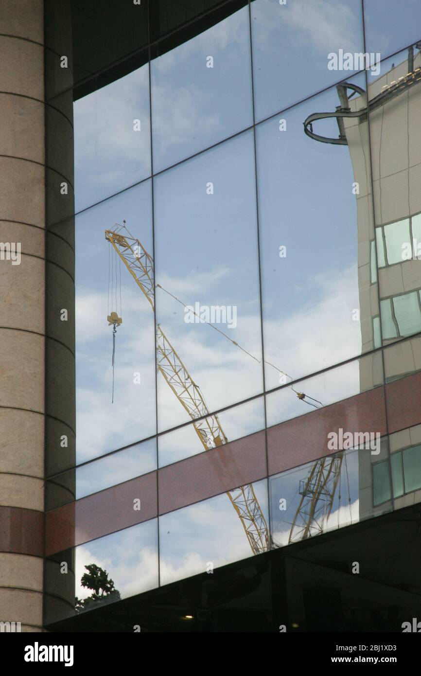 Construction crane reflected in office block window UK Stock Photo - Alamy