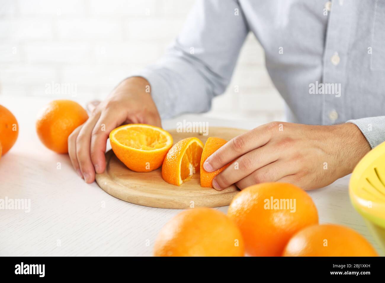 Young man cutting oranges, preparing orange juice Stock Photo - Alamy