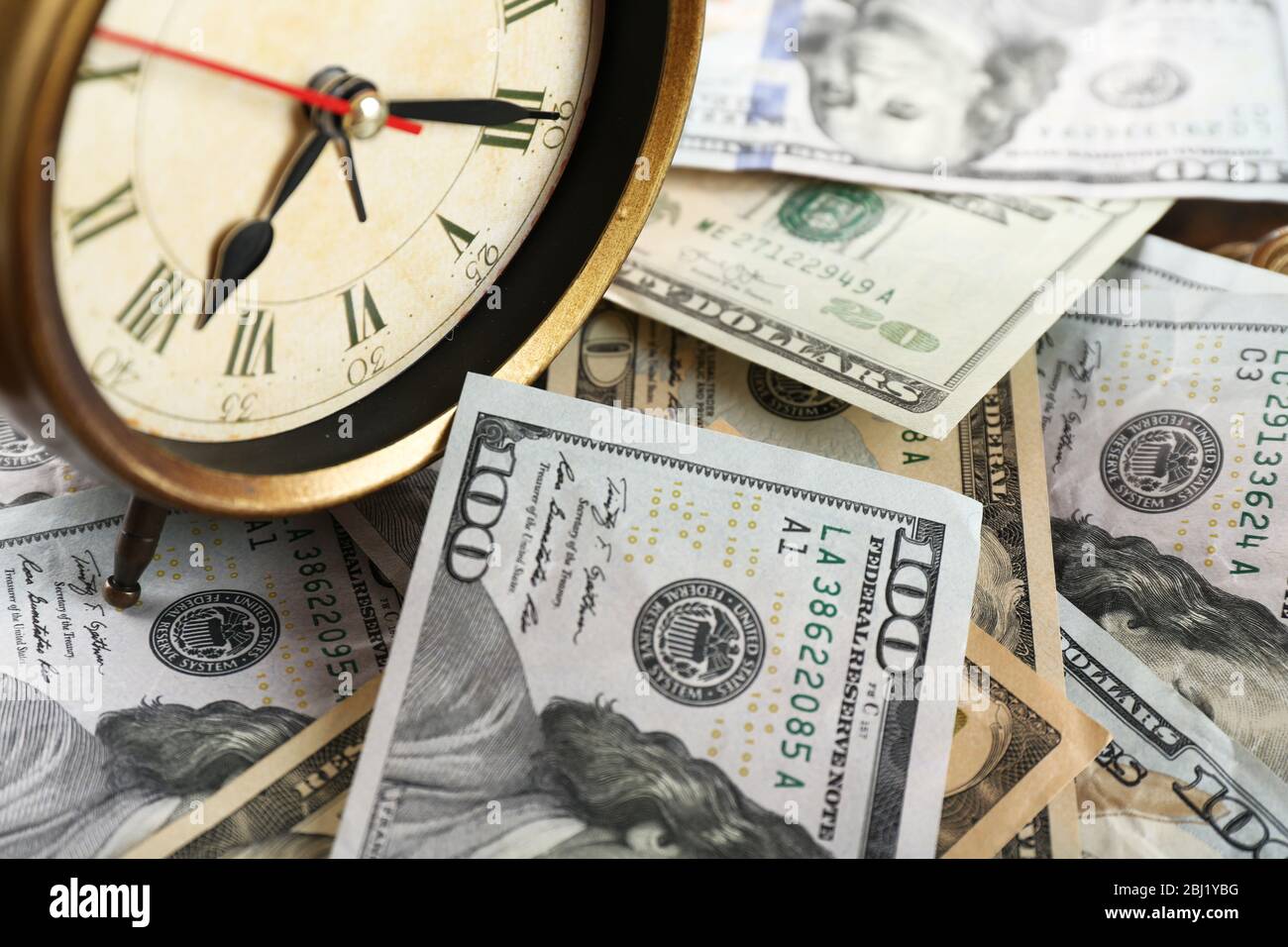 Money and alarm clock, closeup Stock Photo - Alamy