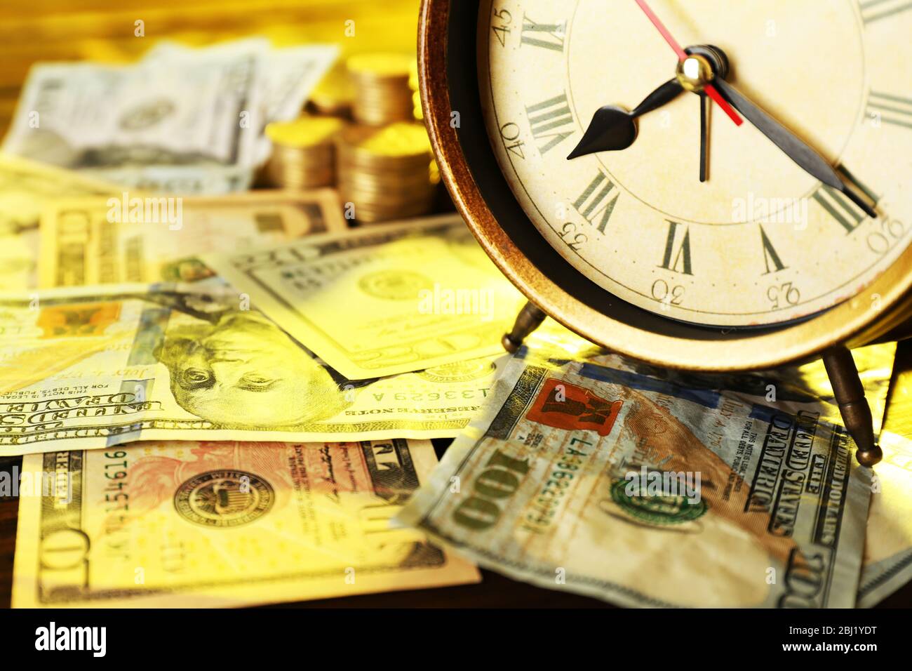 Money and alarm clock, closeup Stock Photo - Alamy