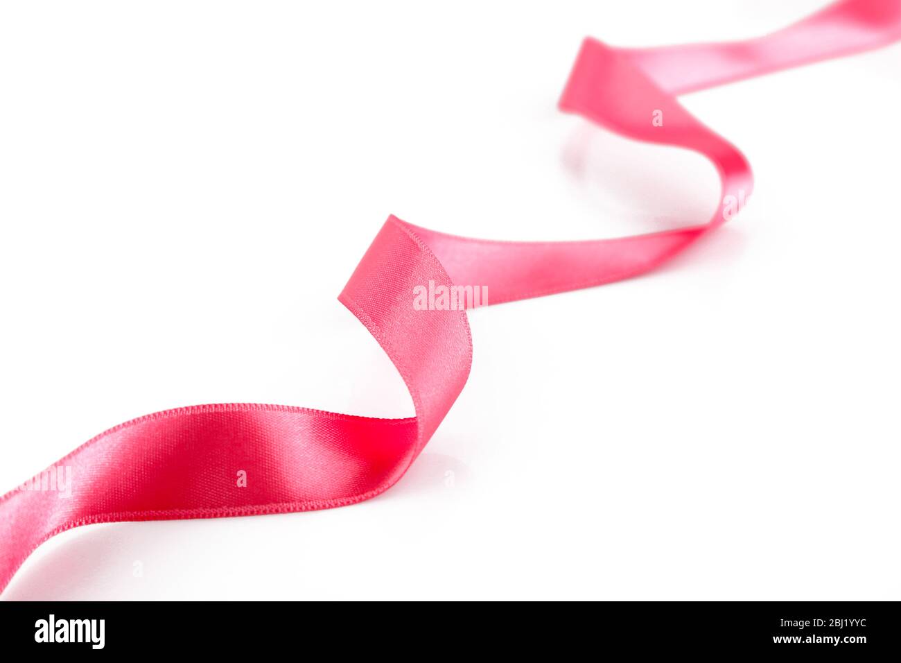 Pink curly ribbon isolated on white Stock Photo - Alamy