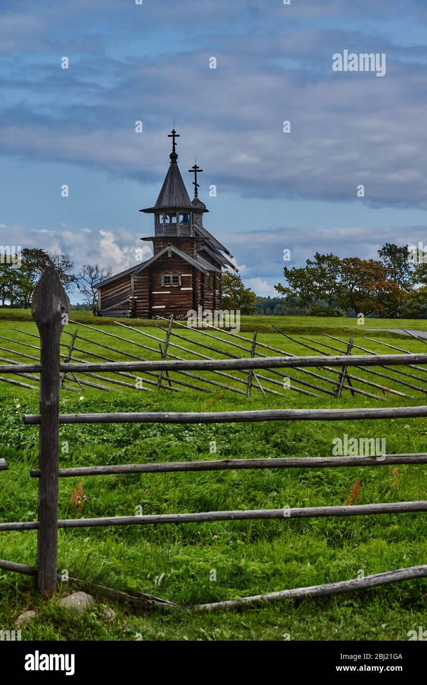 The field is fenced by sloping poles. A typical rural fence around ...