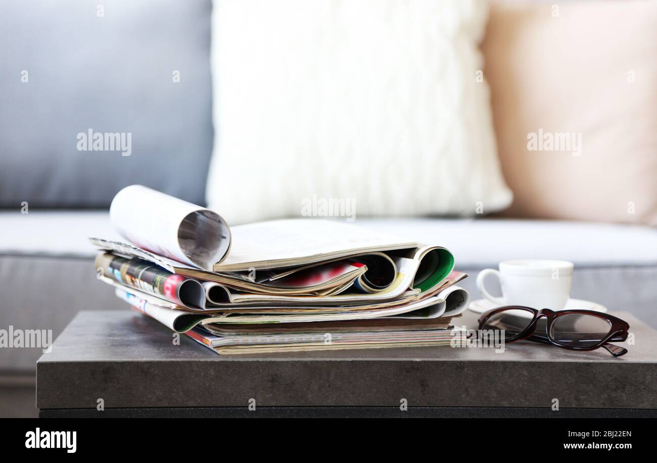 Magazines on table in living room, close up Stock Photo - Alamy