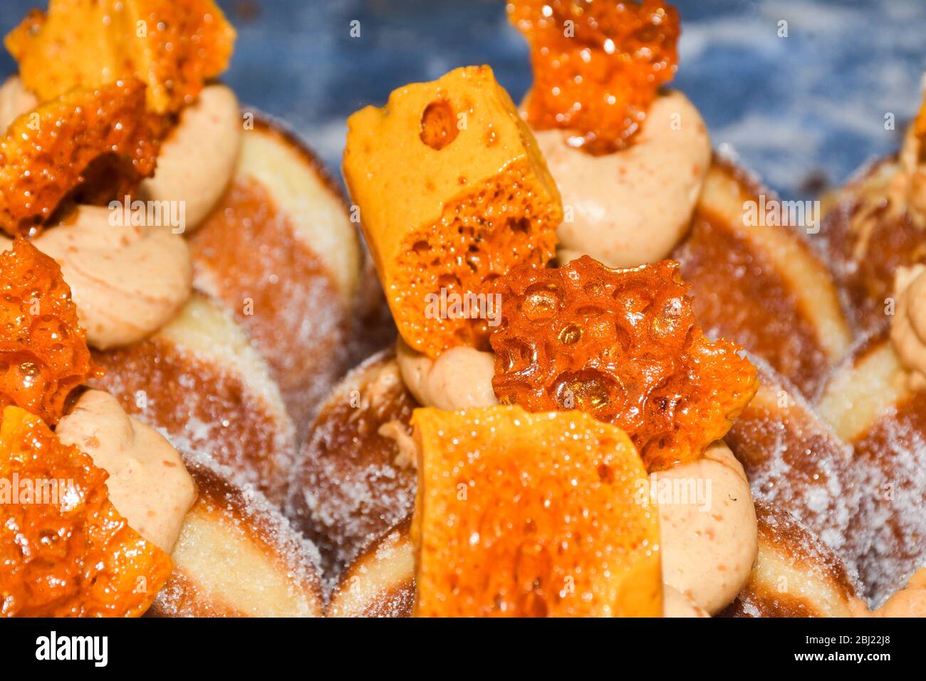 Many donuts placed in a tray, for sale at food market. Close up donuts ...