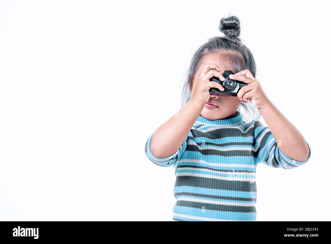 portrait of asian little girl taking a photograph over white background ...