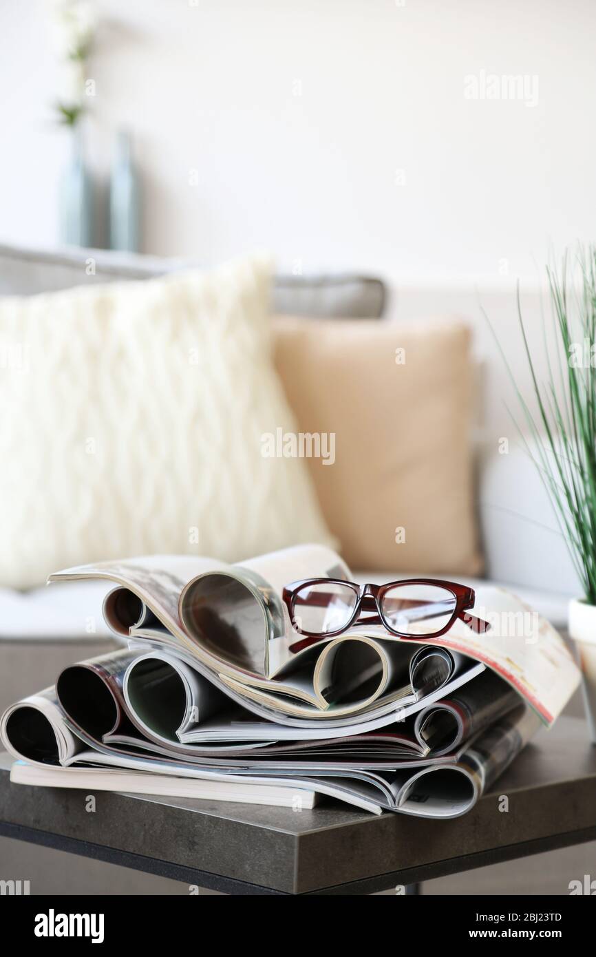 Magazines on table in living room, close up Stock Photo - Alamy