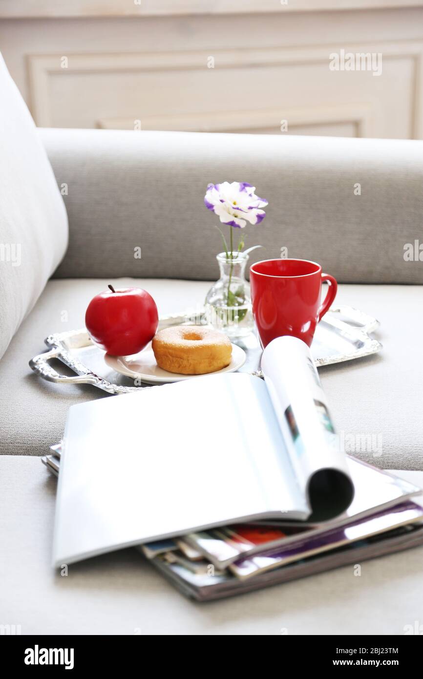 Light breakfast and magazines on sofa in living room, close up Stock ...