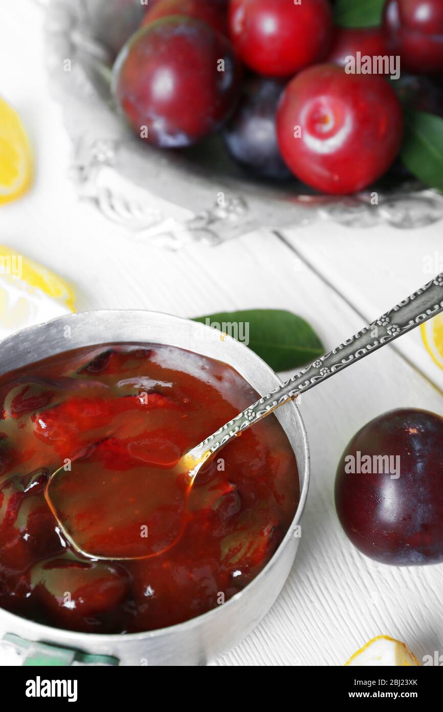 Tasty homemade plum jam in stew pot on wooden table, closeup Stock ...