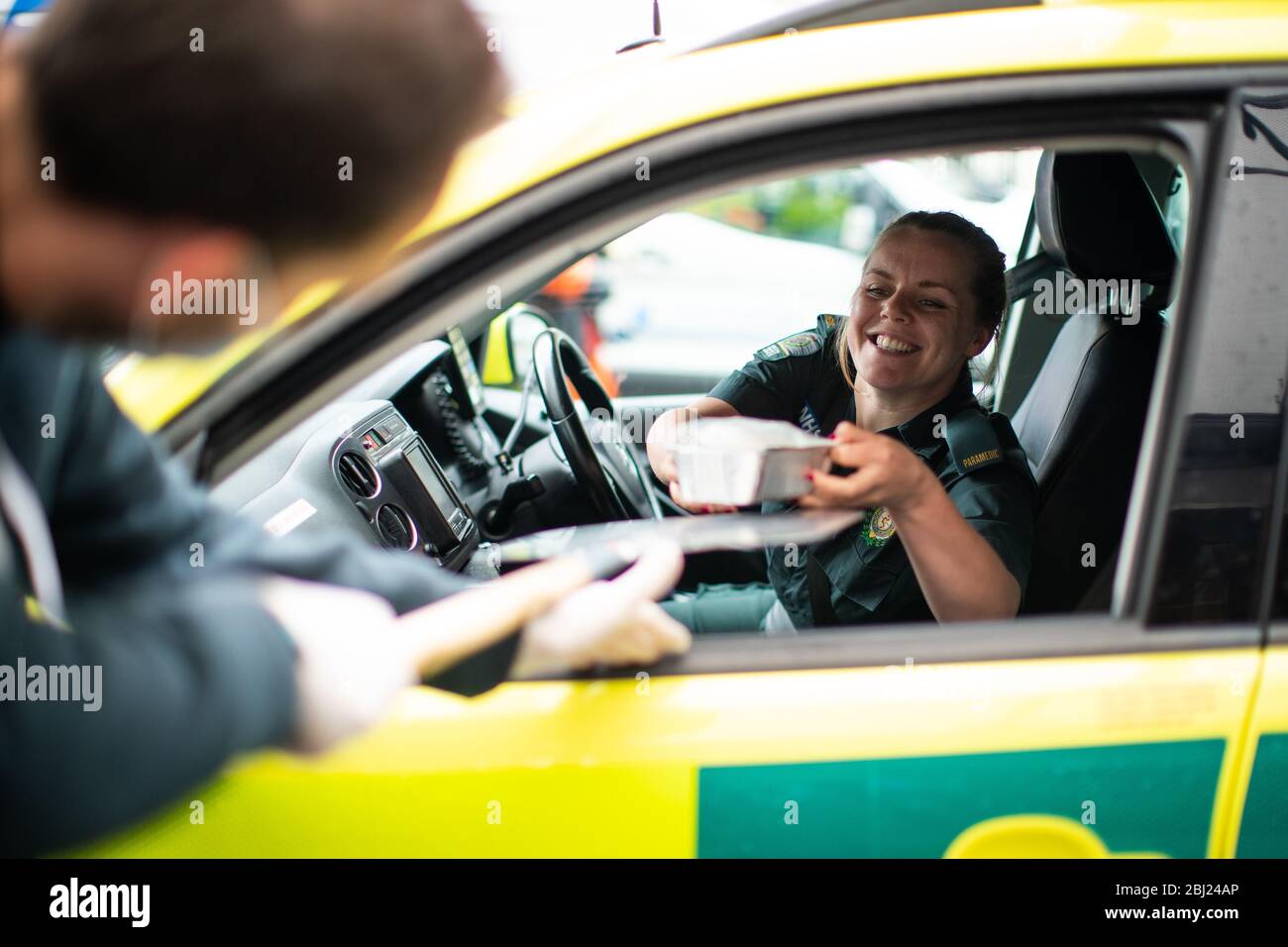 Food and drink is passed into a an ambulance car hi-res stock ...