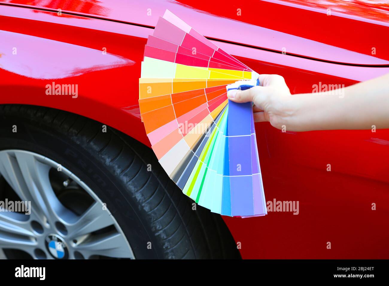 Female hand with color samples over red car background Stock Photo - Alamy