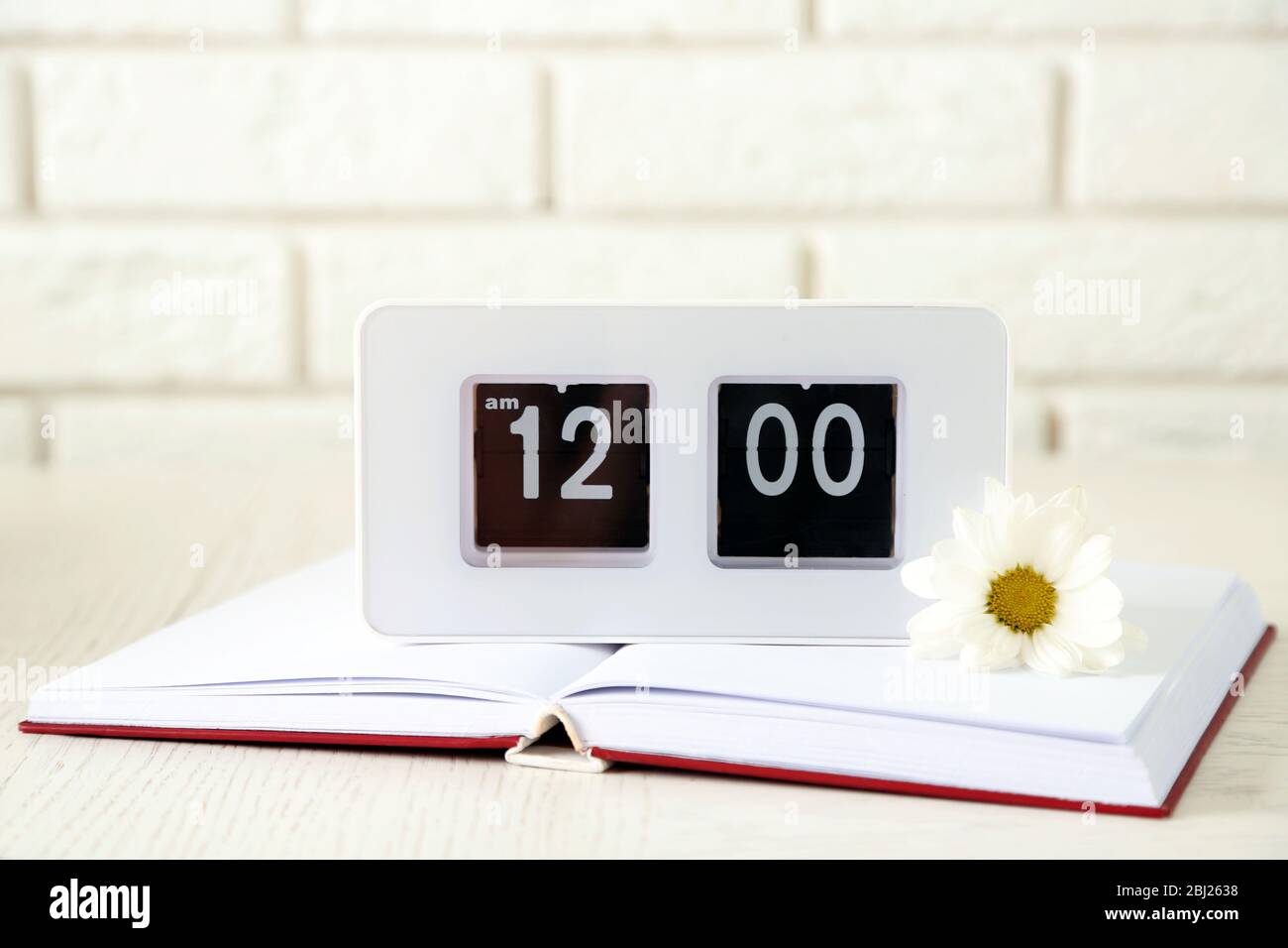 Modern Clock and book, on light wall background Stock Photo - Alamy