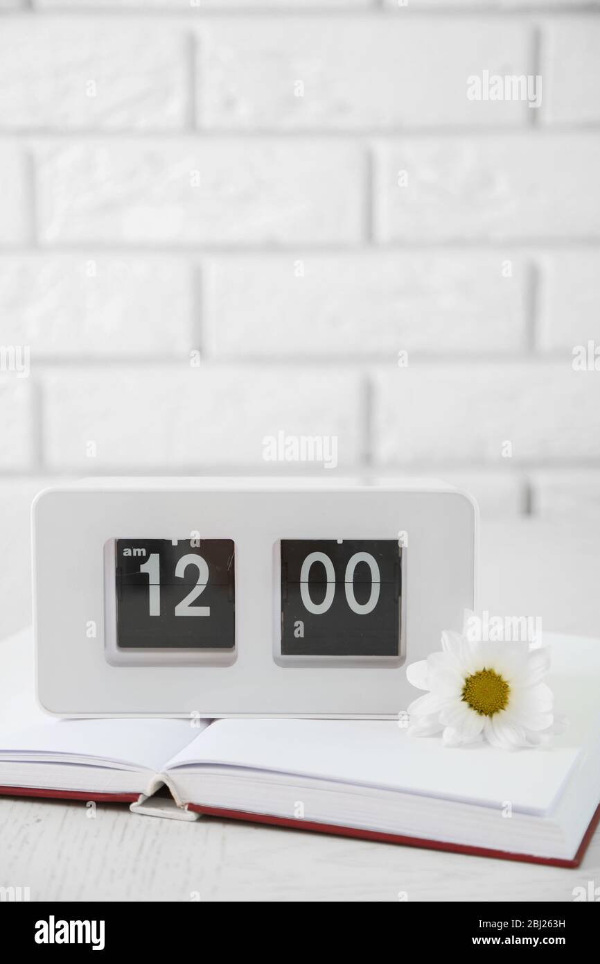 Modern Clock and book, on light wall background Stock Photo - Alamy