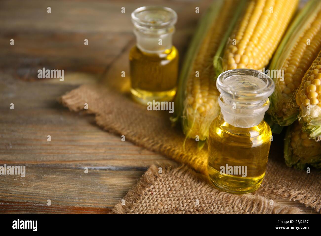 Fresh corn with bottles of oil on table close up Stock Photo - Alamy