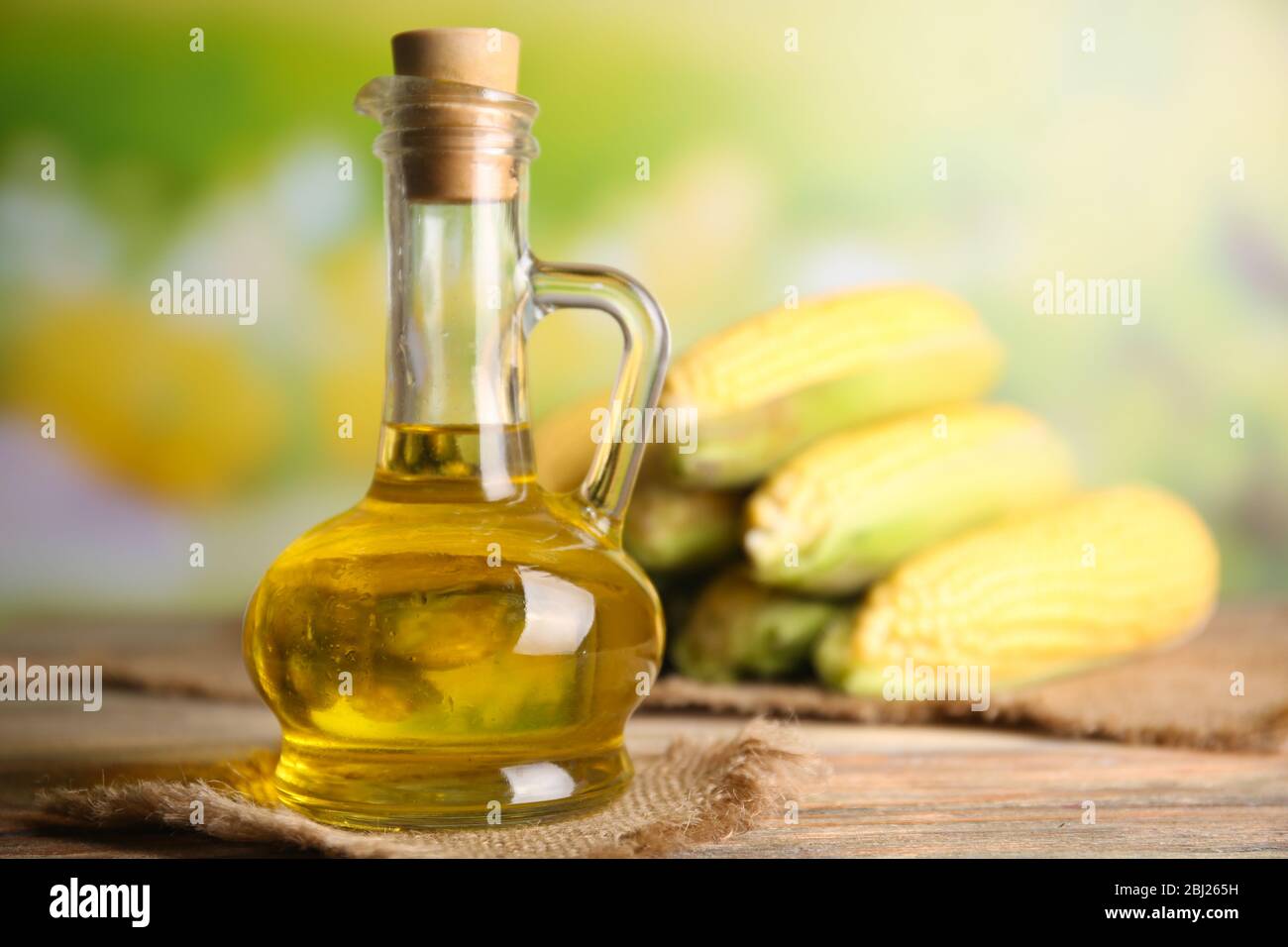 Bottle of oil with fresh corn on bright background Stock Photo - Alamy