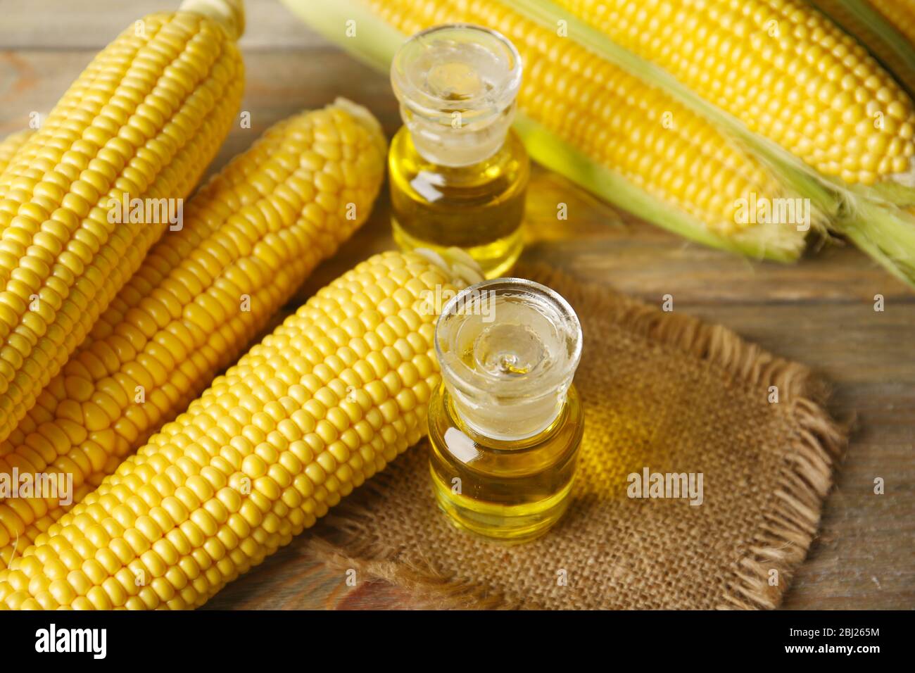 Fresh corn with bottles of oil on table close up Stock Photo - Alamy