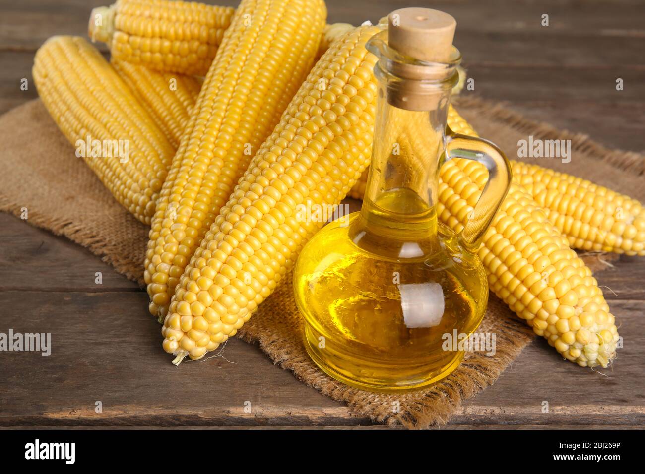 Fresh corn with bottle of oil on table close up Stock Photo - Alamy