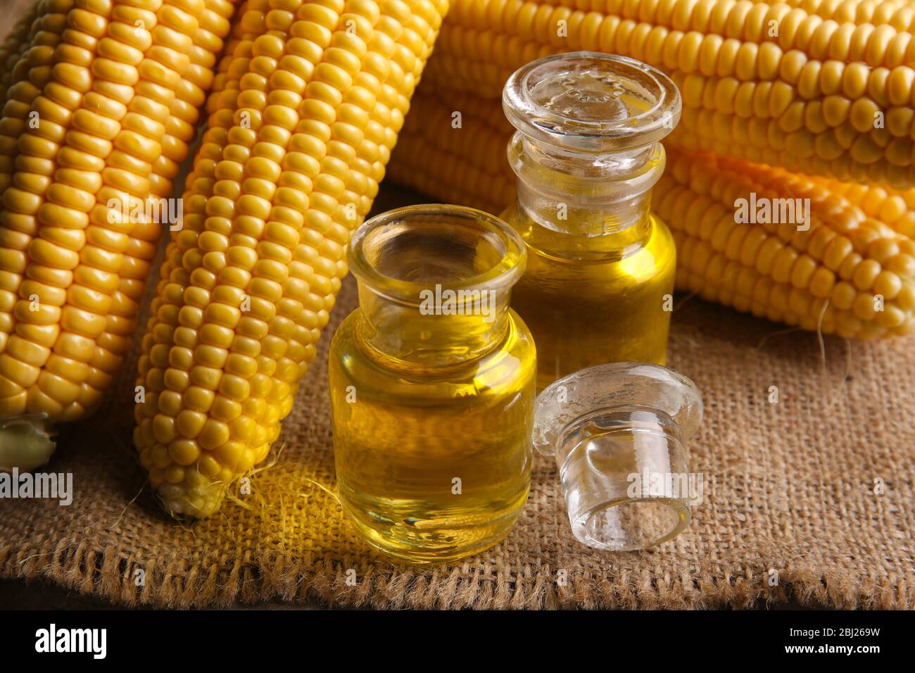 Fresh corn with bottles of oil on table close up Stock Photo - Alamy