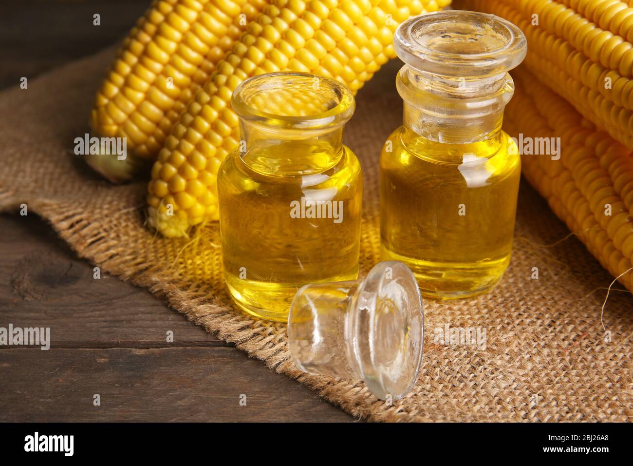 Fresh corn with bottles of oil on table close up Stock Photo - Alamy