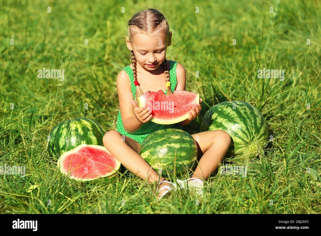 Small girl with watermelons on lawn Stock Photo - Alamy