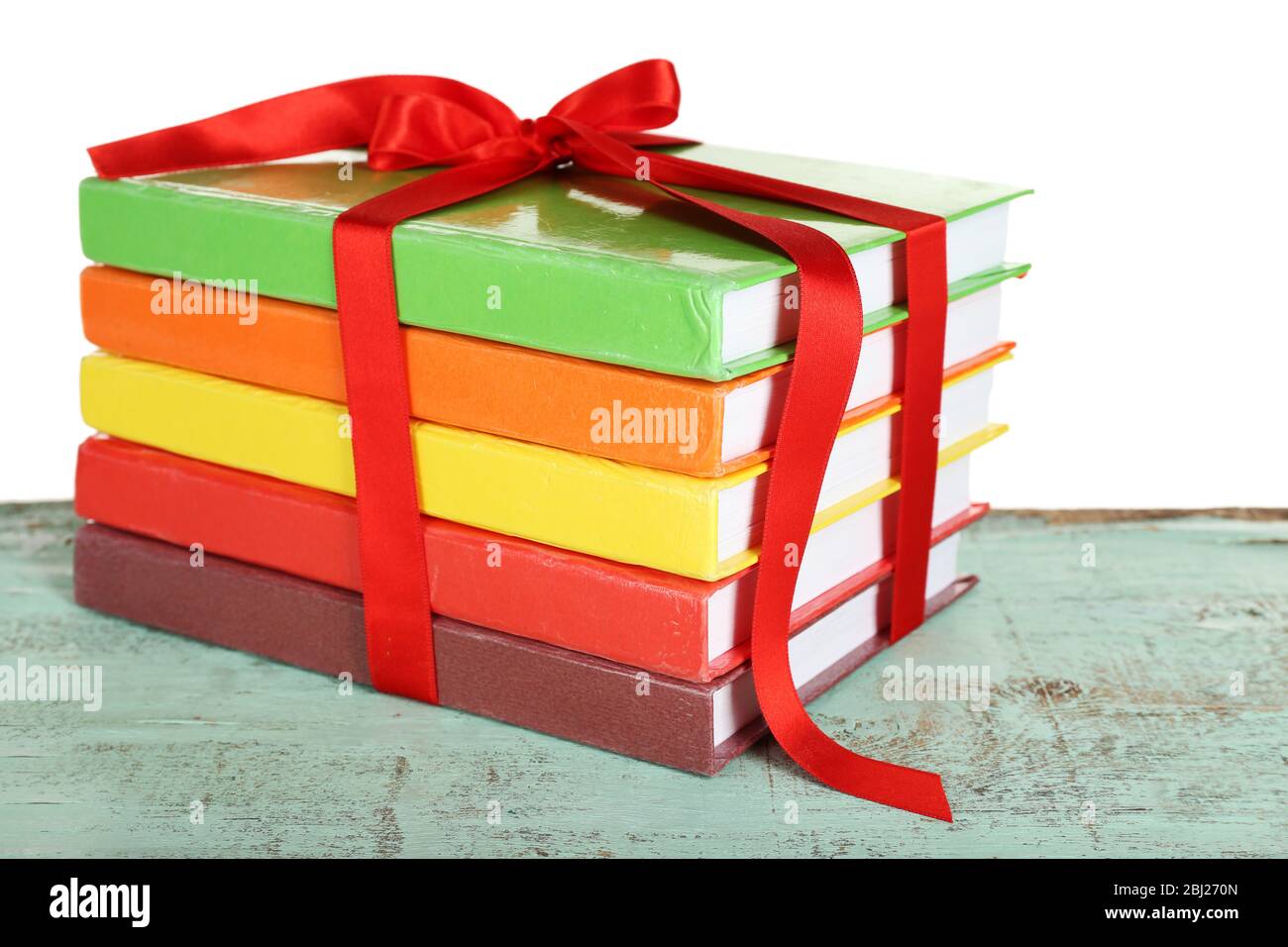 Stack of books with ribbon on light background Stock Photo - Alamy