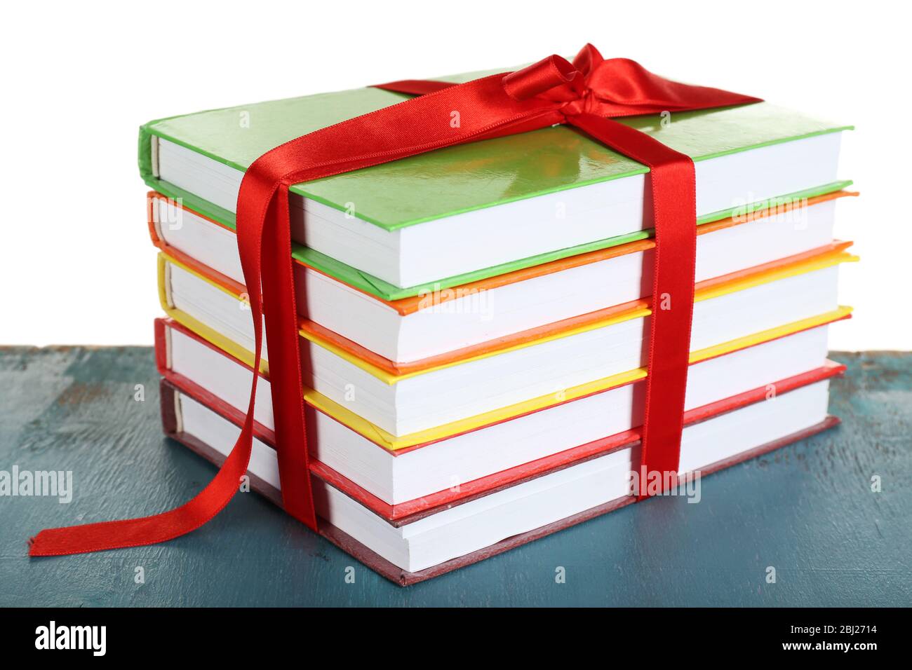 Stack of books with ribbon on light background Stock Photo - Alamy