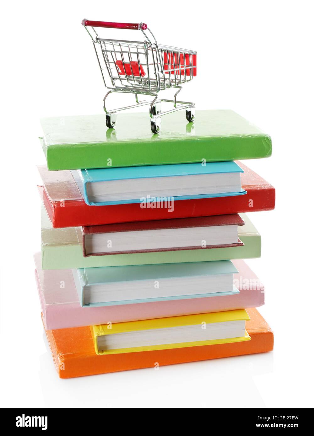 Stack of colorful books with small shopping cart isolated on white ...