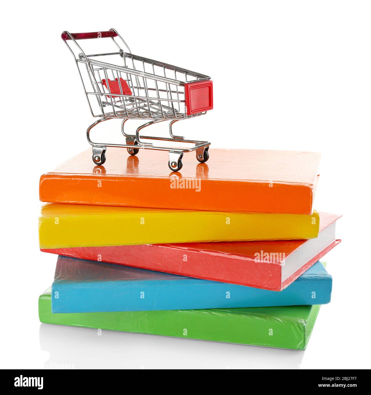 Stack of colorful books with small shopping cart isolated on white ...