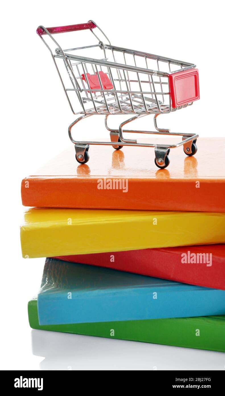 Stack of colorful books with small shopping cart isolated on white ...