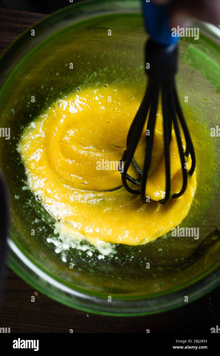 Mxing eggs with sugar , flour and butter to bake a cake Stock Photo - Alamy
