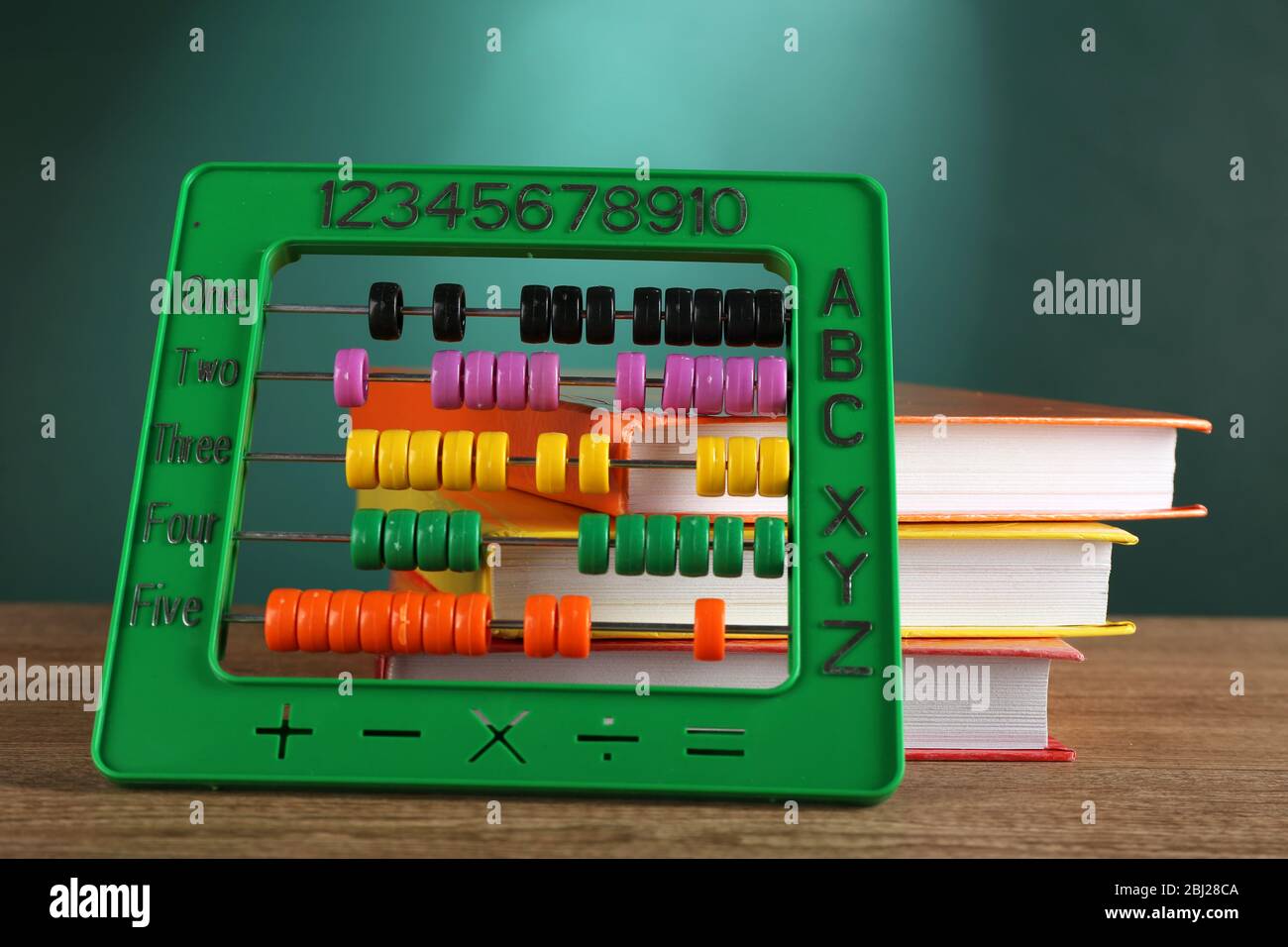 Abacus and stack of books on desk on green chalkboard background Stock ...