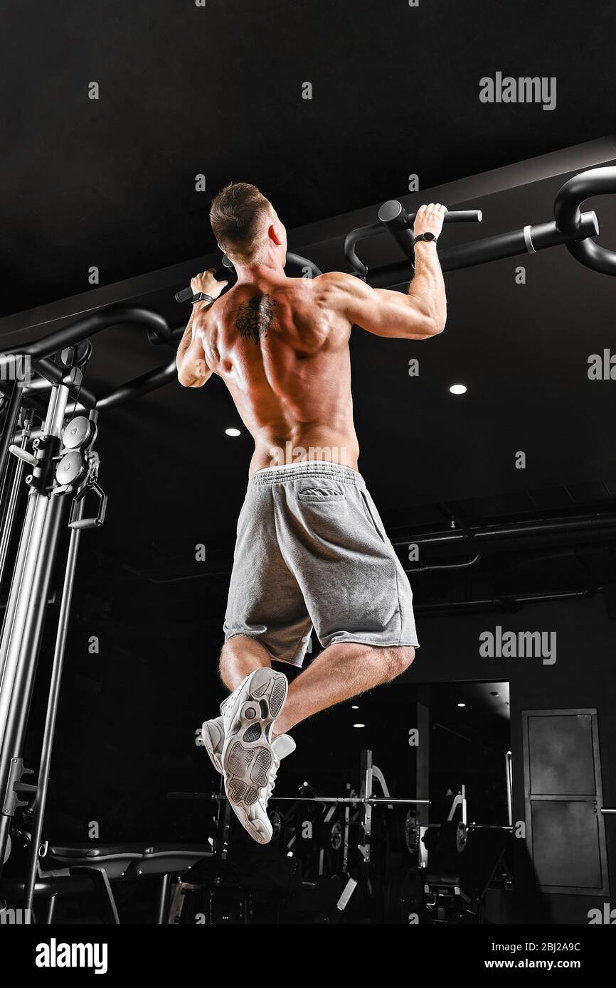 Bodybuilder does pull-ups. Muscular man in the gym. Preparation for ...