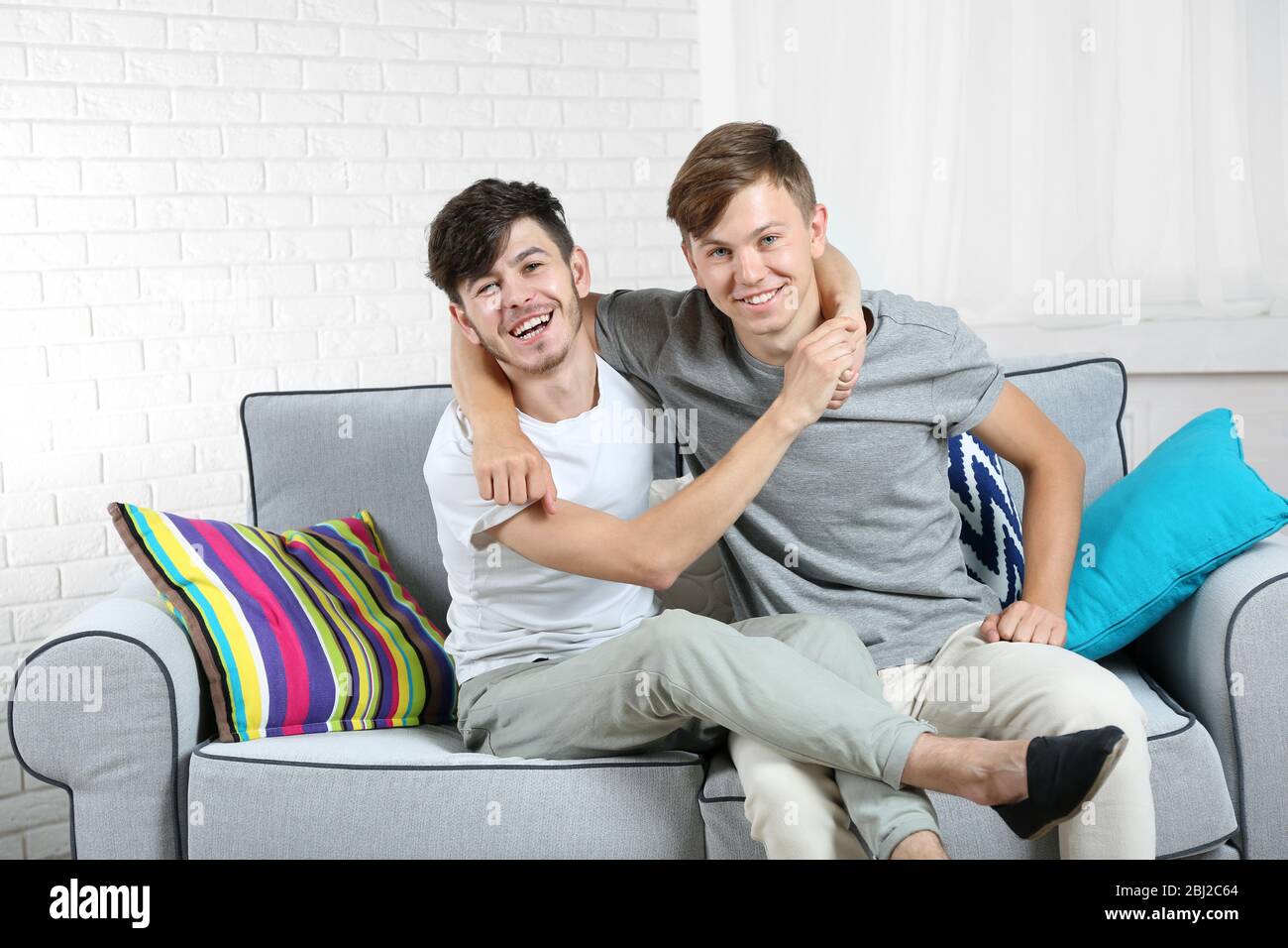 Happy family portrait with two brothers on sofa at home Stock Photo - Alamy