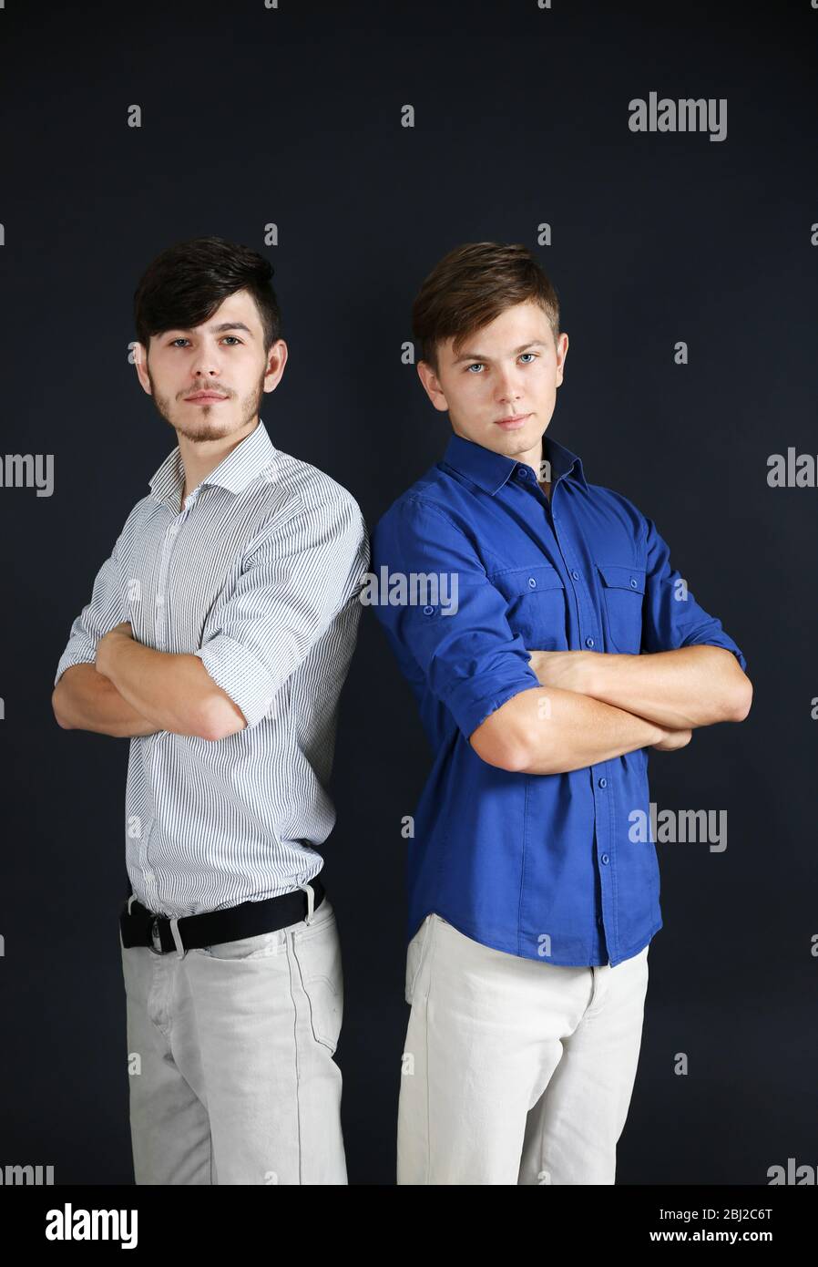 Two brothers on dark background Stock Photo - Alamy