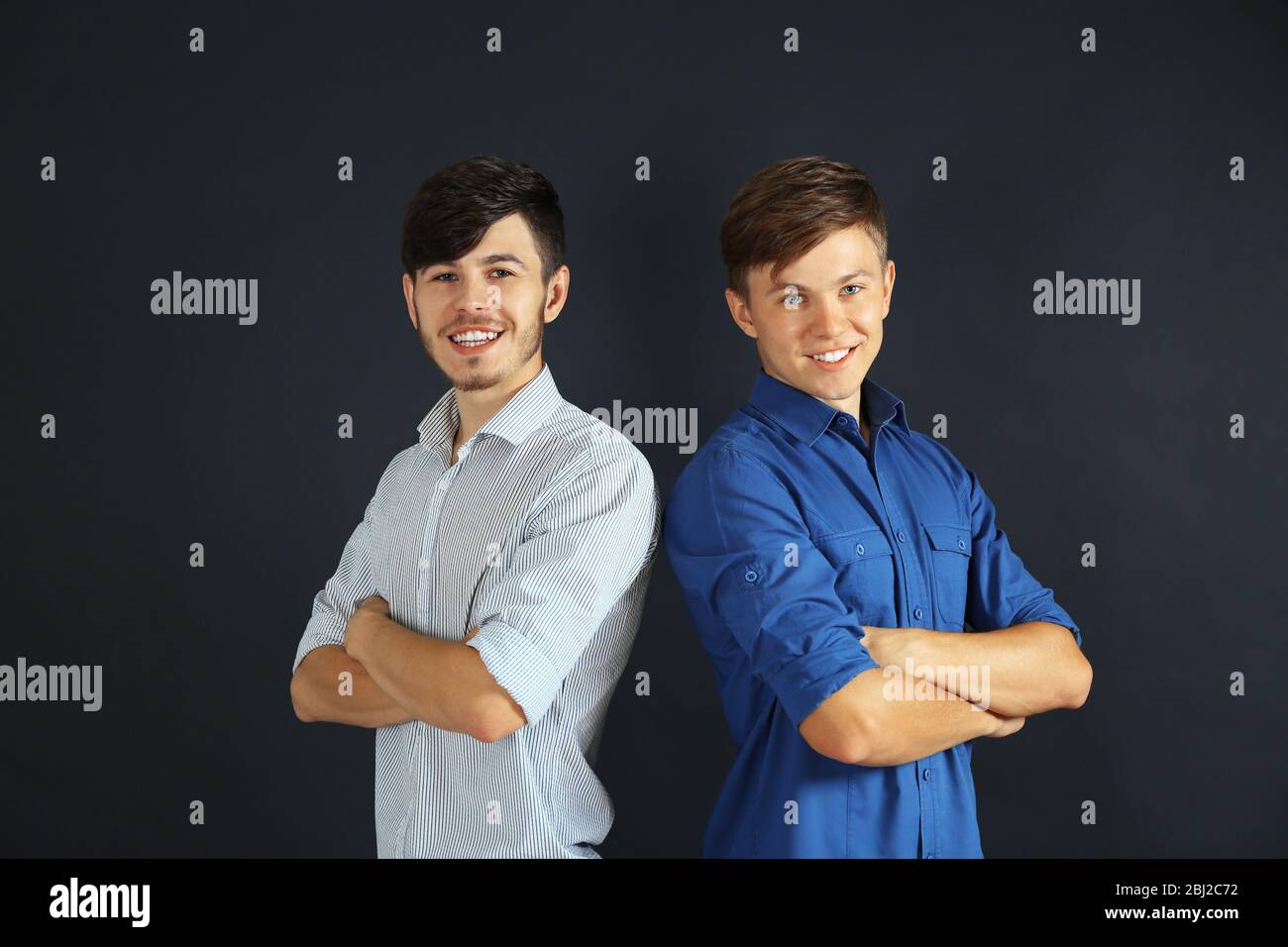 Two brothers on dark background Stock Photo - Alamy